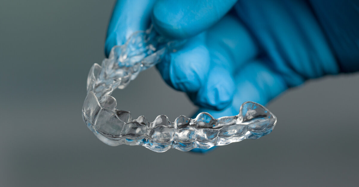 Adhesive-free bonding of metal buttons to clear aligners